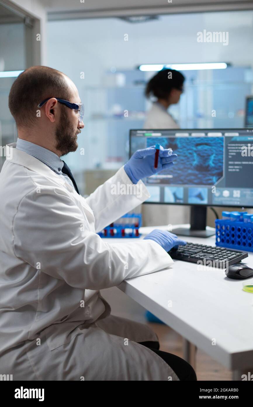 Biologist researcher man holding medical vacutainer with blood sample ...