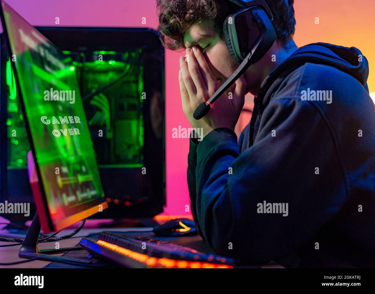 Upset gamer sitting near computer Stock Photo - Alamy