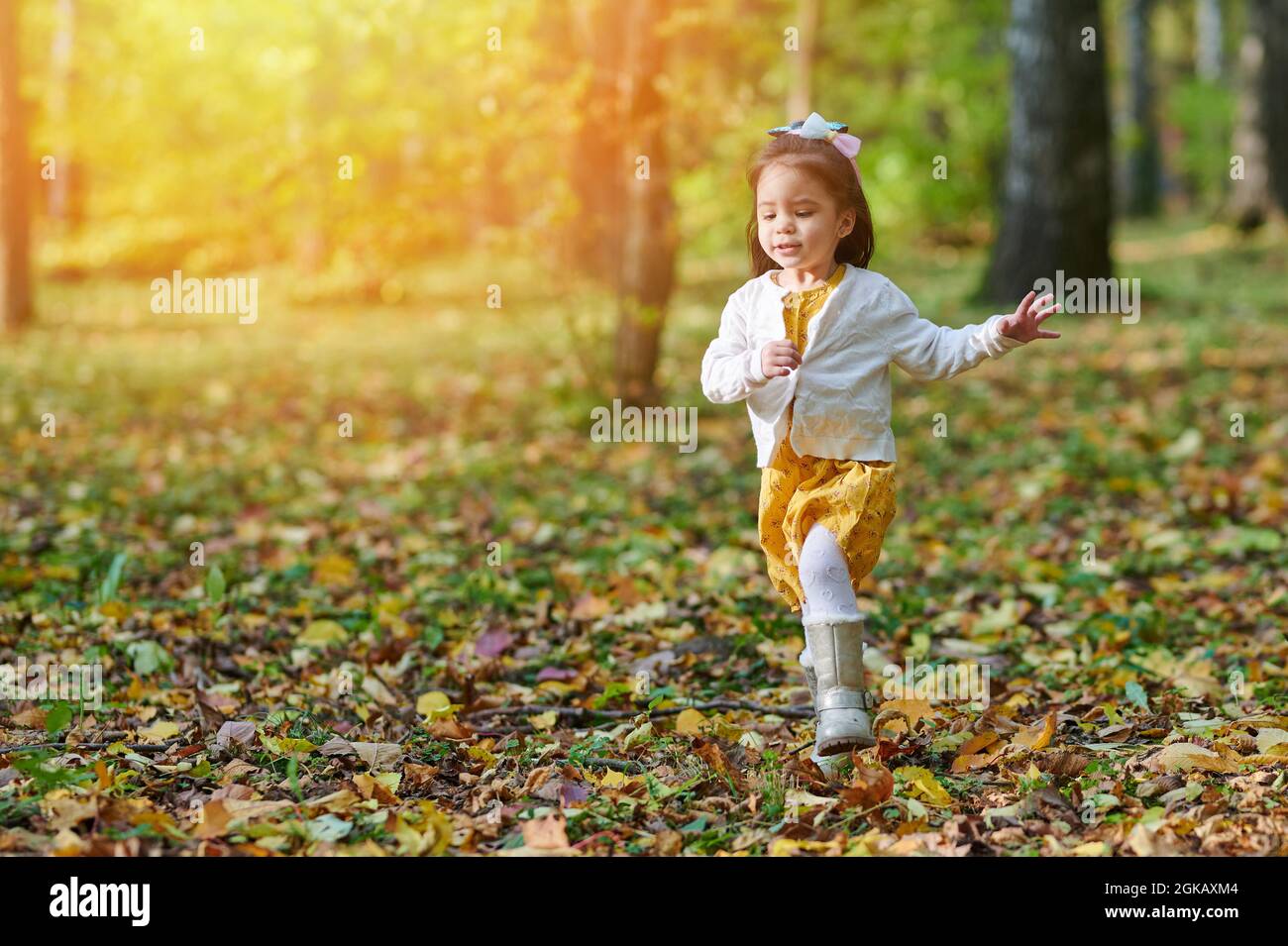 Scared small girl run in yellow park background Stock Photo - Alamy