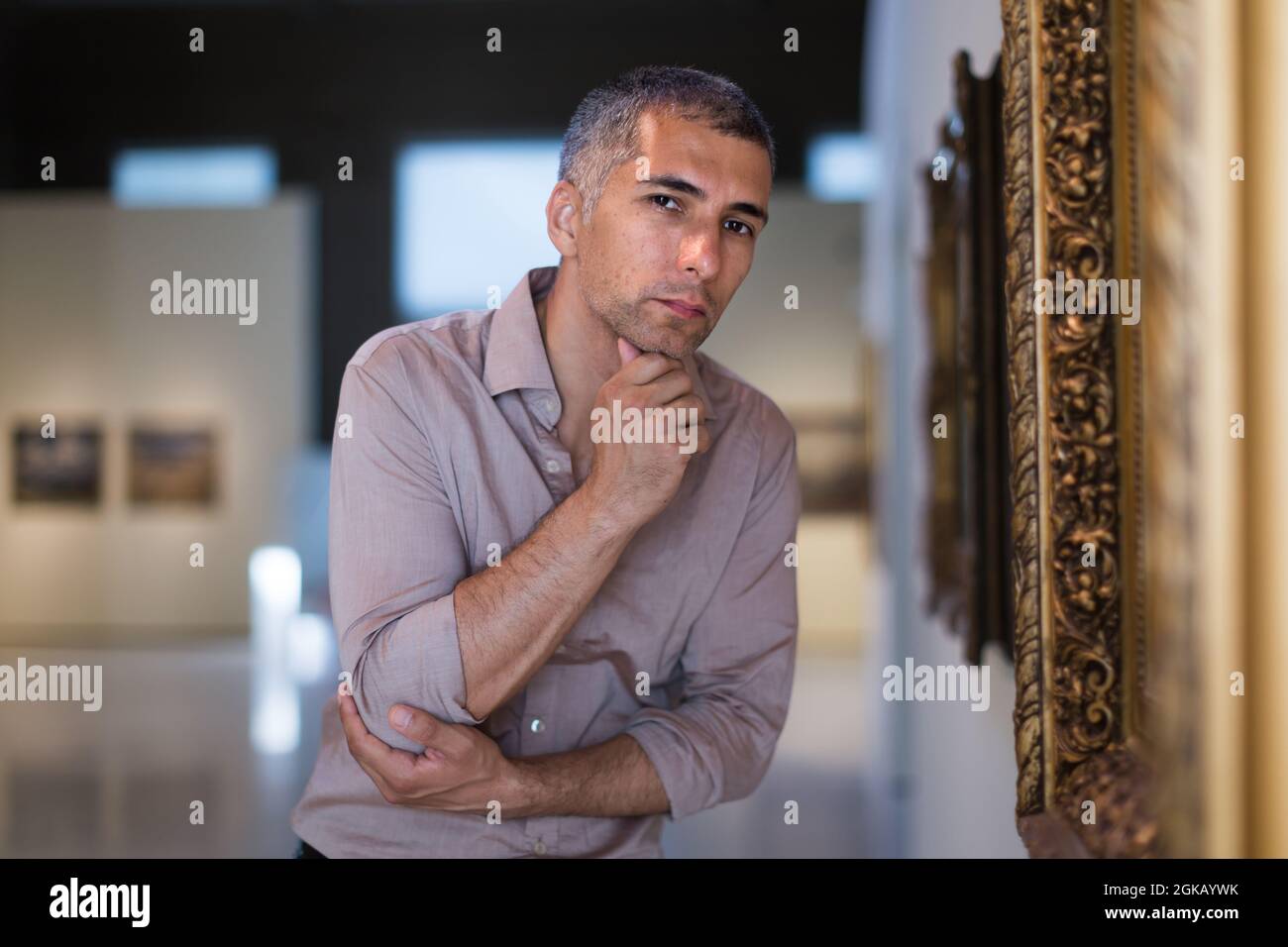Adult man is visiting museum and looking at the pictures Stock Photo ...