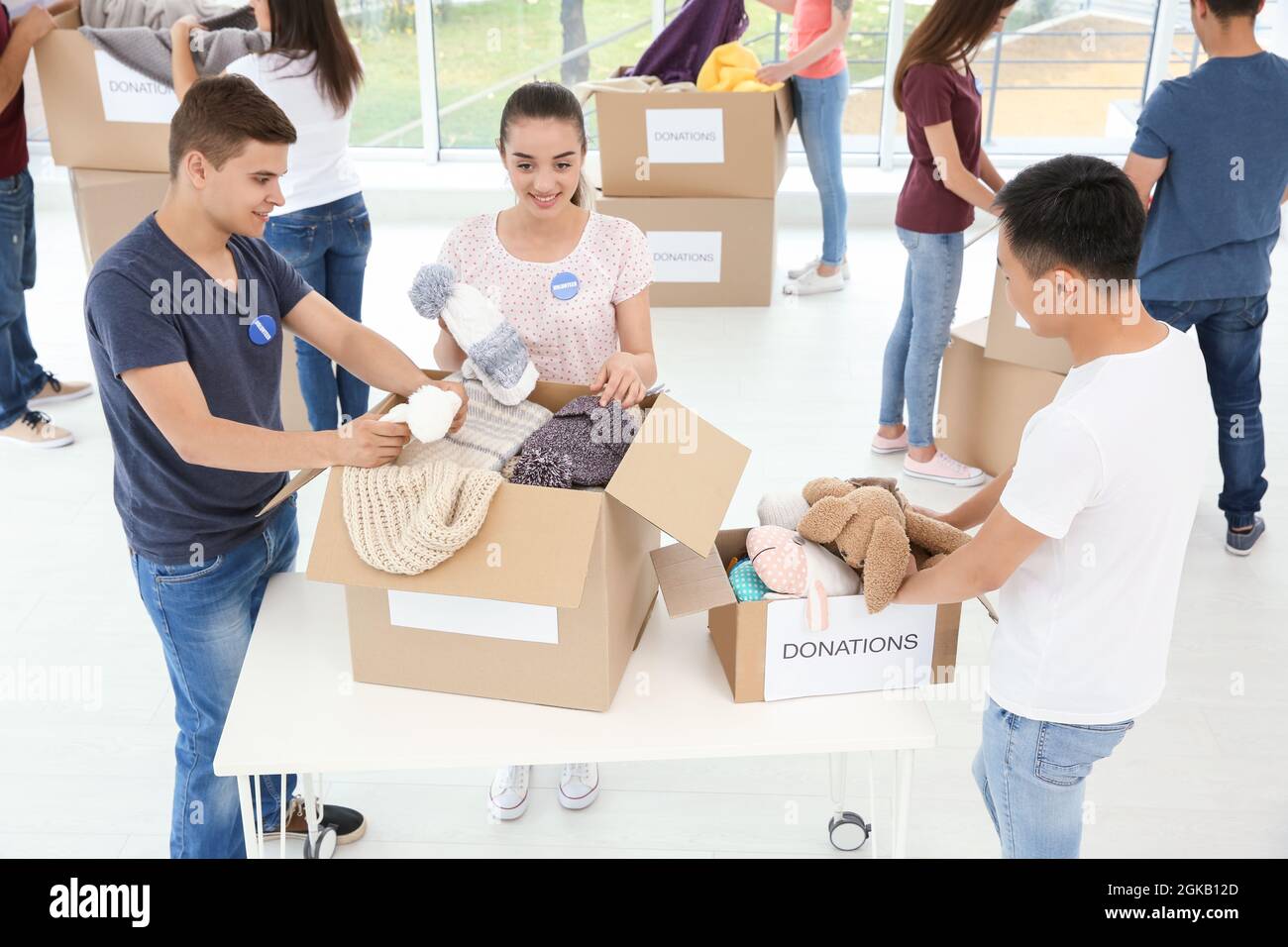 Team of teen volunteers collecting donated clothes and toys in ...
