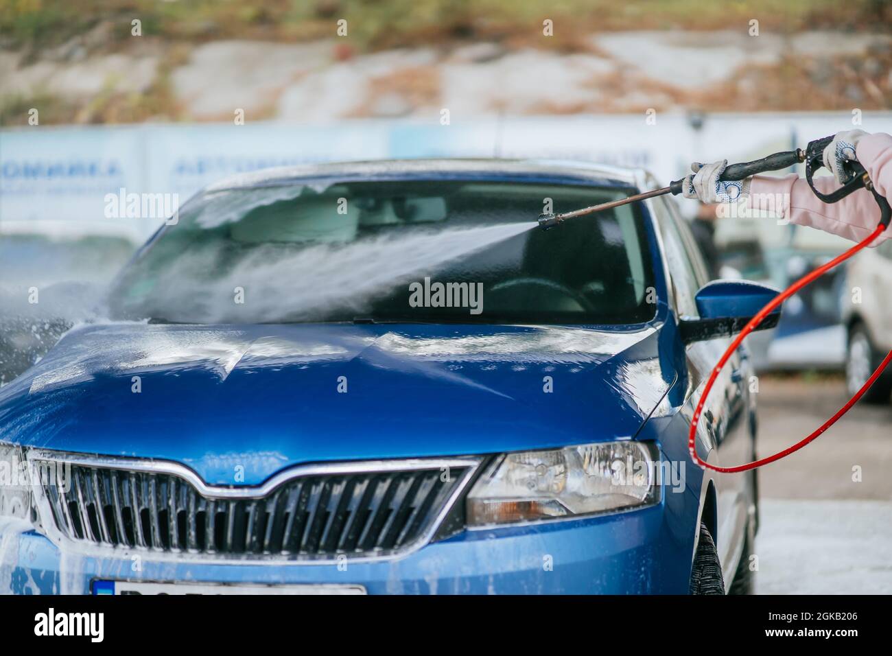Young woman washing blue car at car wash Stock Photo - Alamy