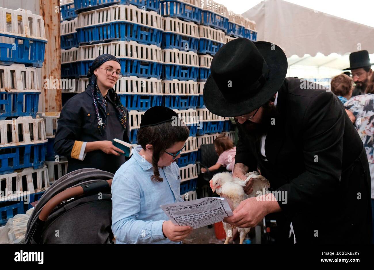 An ultra-Orthodox Jewish man holds a chicken as he performs the ...