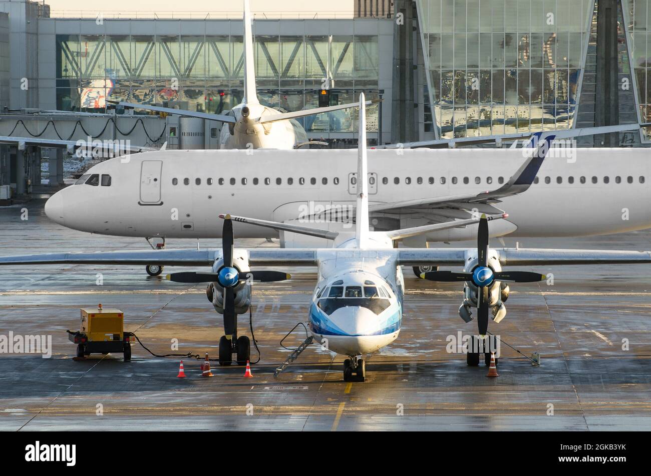 Turboprop aircraft parked behind the jet plane taxiing Stock Photo - Alamy