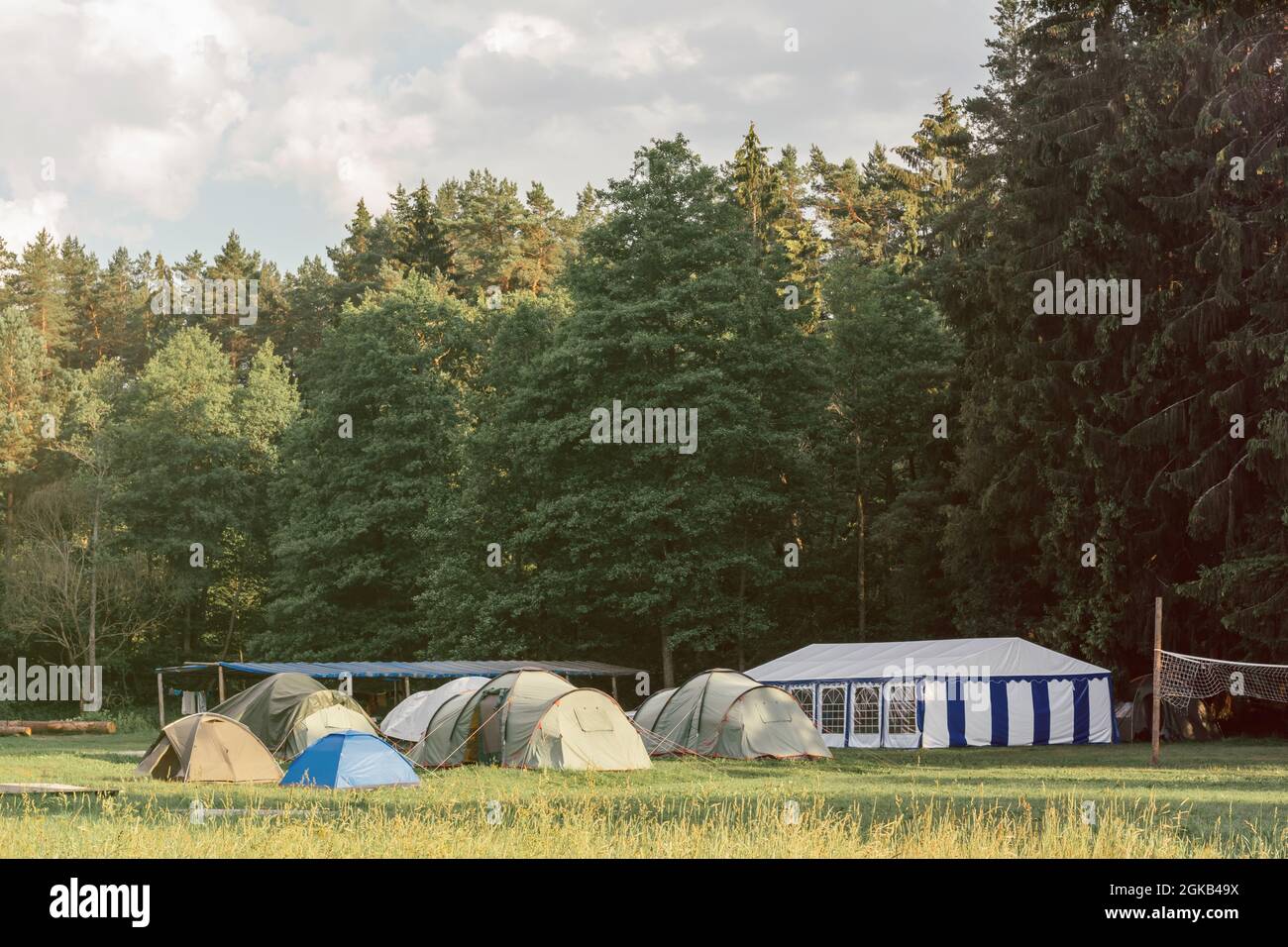 Tent town against backdrop of forest on meadow with pavilion and ...
