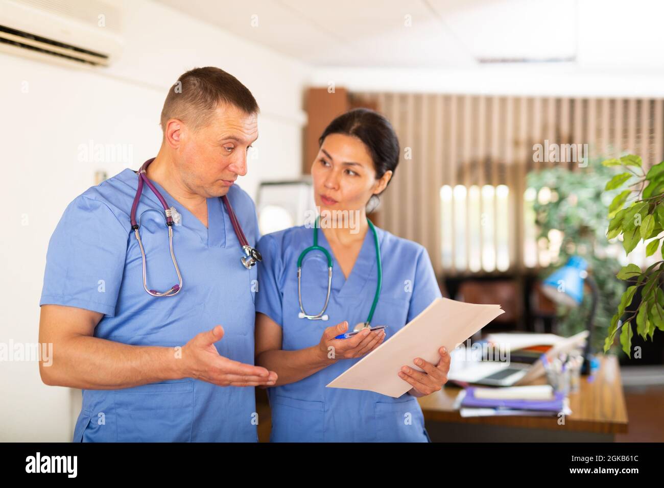Two doctors checking patient papers in clinic Stock Photo - Alamy
