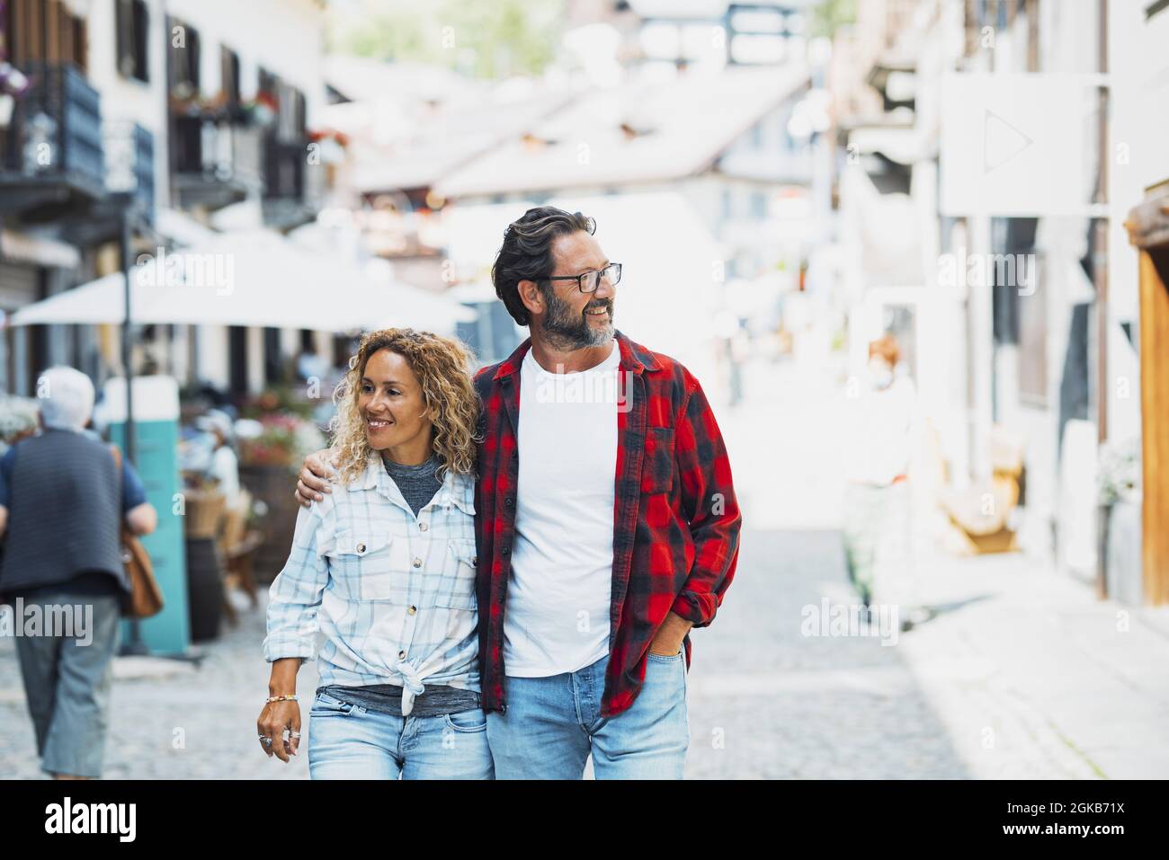 Couple embracing while walking on city street. Happy couple enjoying ...