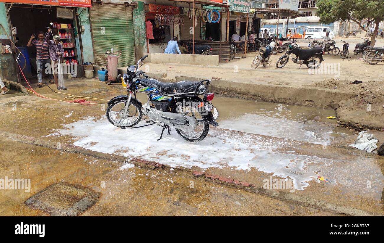 Washing motorcycle with high pressure jet, close-up. Bike cleaning with ...