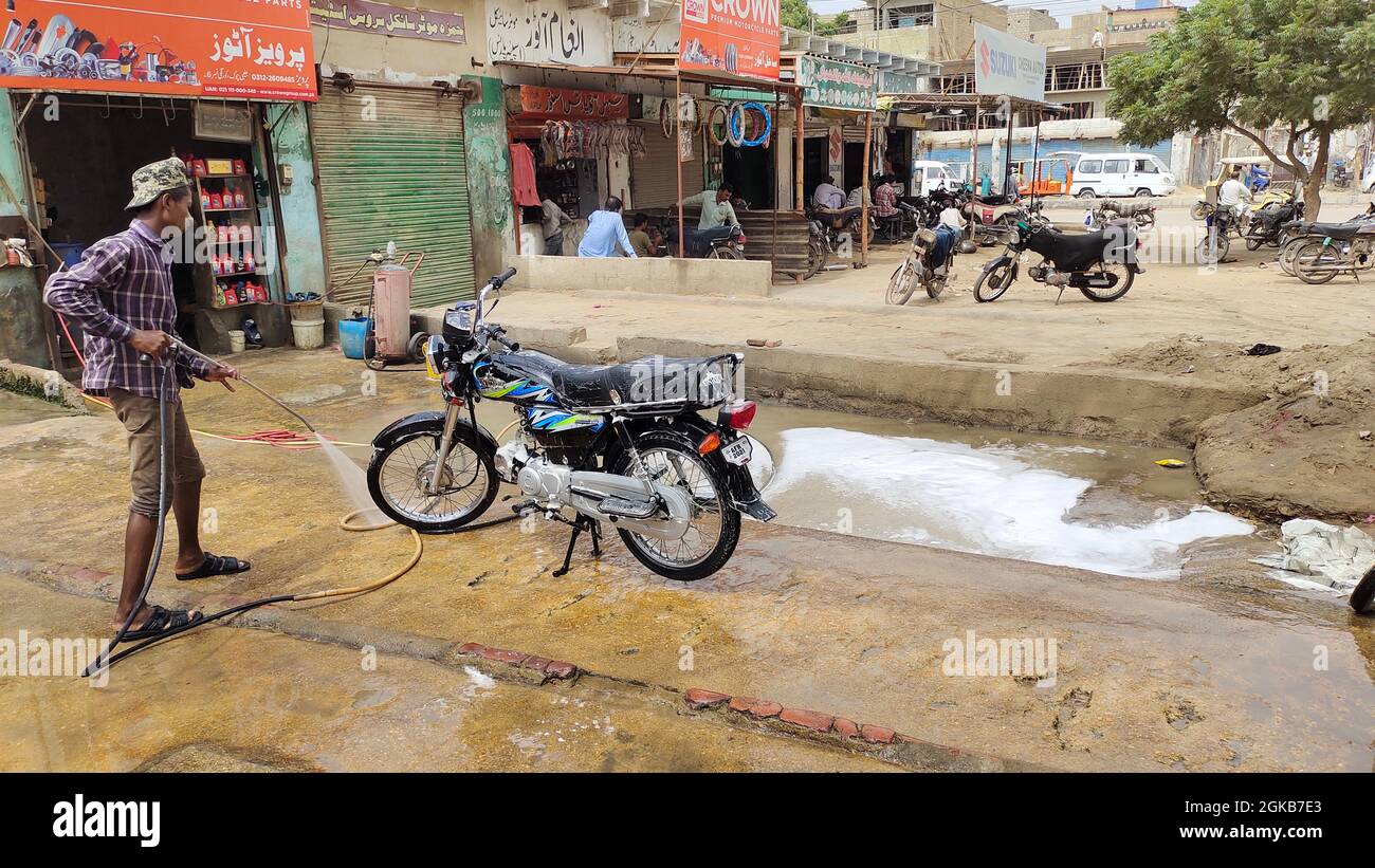 Washing motorcycle with high pressure jet, close-up. Bike cleaning with ...