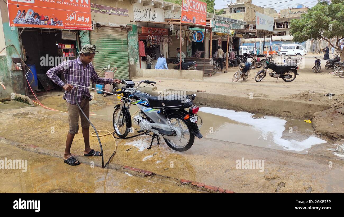 Washing motorcycle with high pressure jet, close-up. Bike cleaning with ...