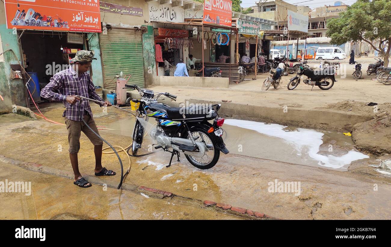 Washing motorcycle with high pressure jet, close-up. Bike cleaning with ...