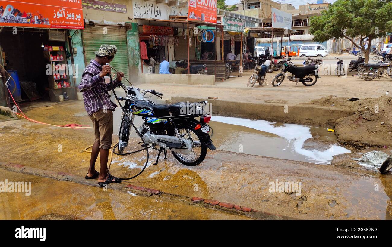 Washing motorcycle with high pressure jet, close-up. Bike cleaning with ...