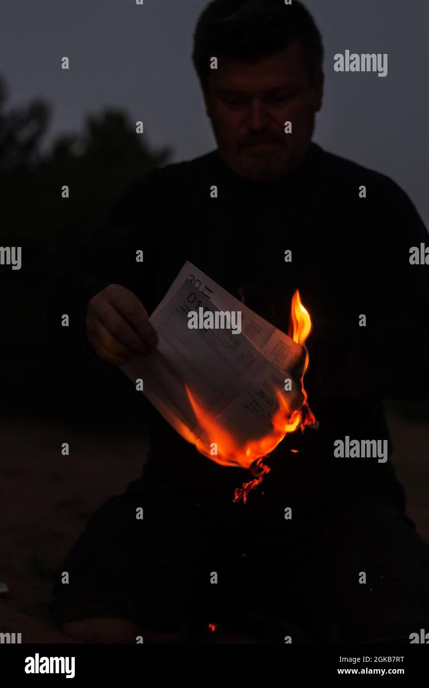 An adult male holds on to the burning documents. Sheets tore out Stock ...
