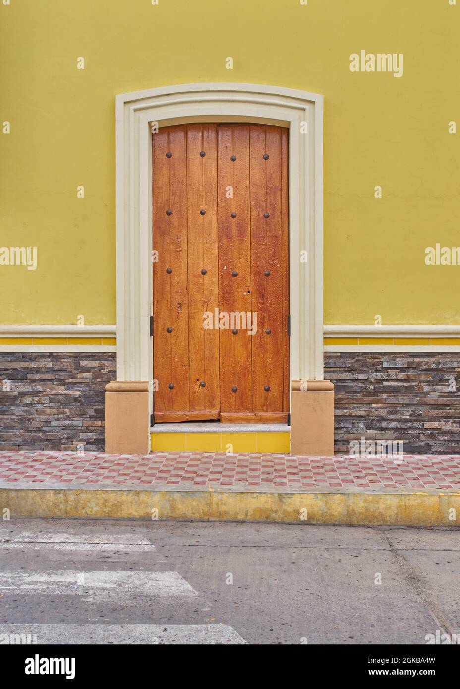 Mustard yellow painted antique wooden door facade Stock Photo - Alamy