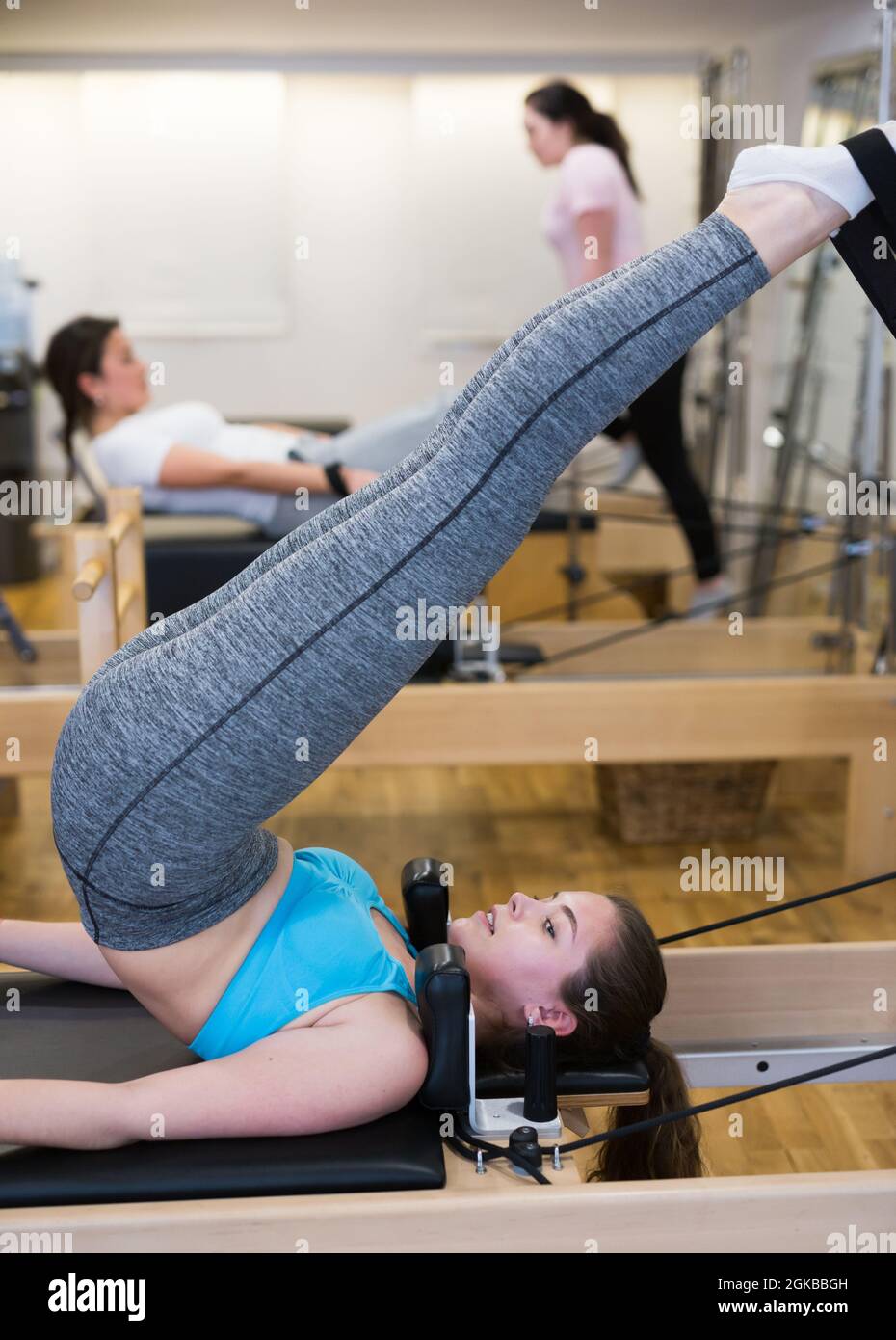 Woman exercising torson rotation at gym using pilates beds Stock Photo ...