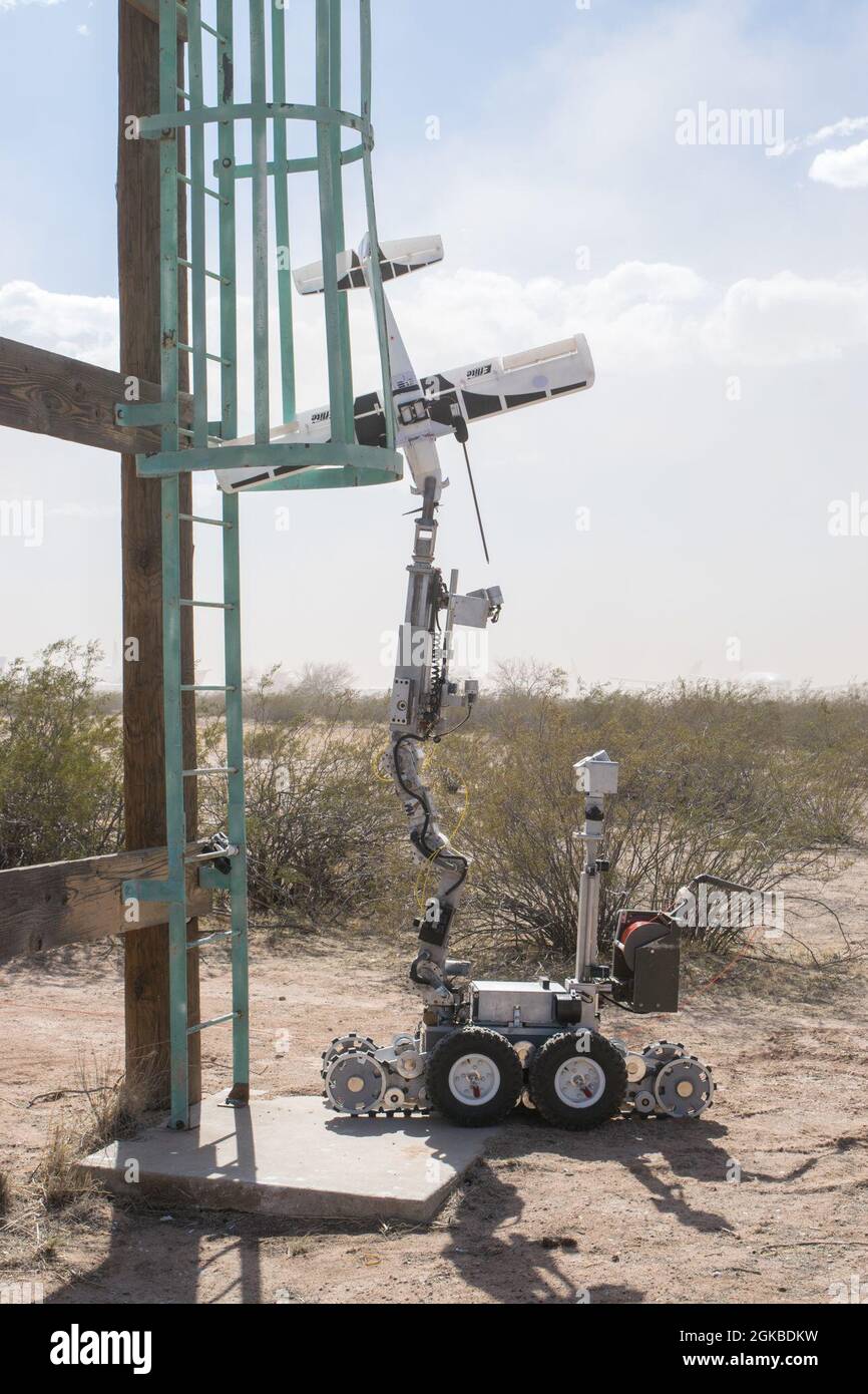 An F-6 Robot reaches for remote-control airplane during a training lane ...