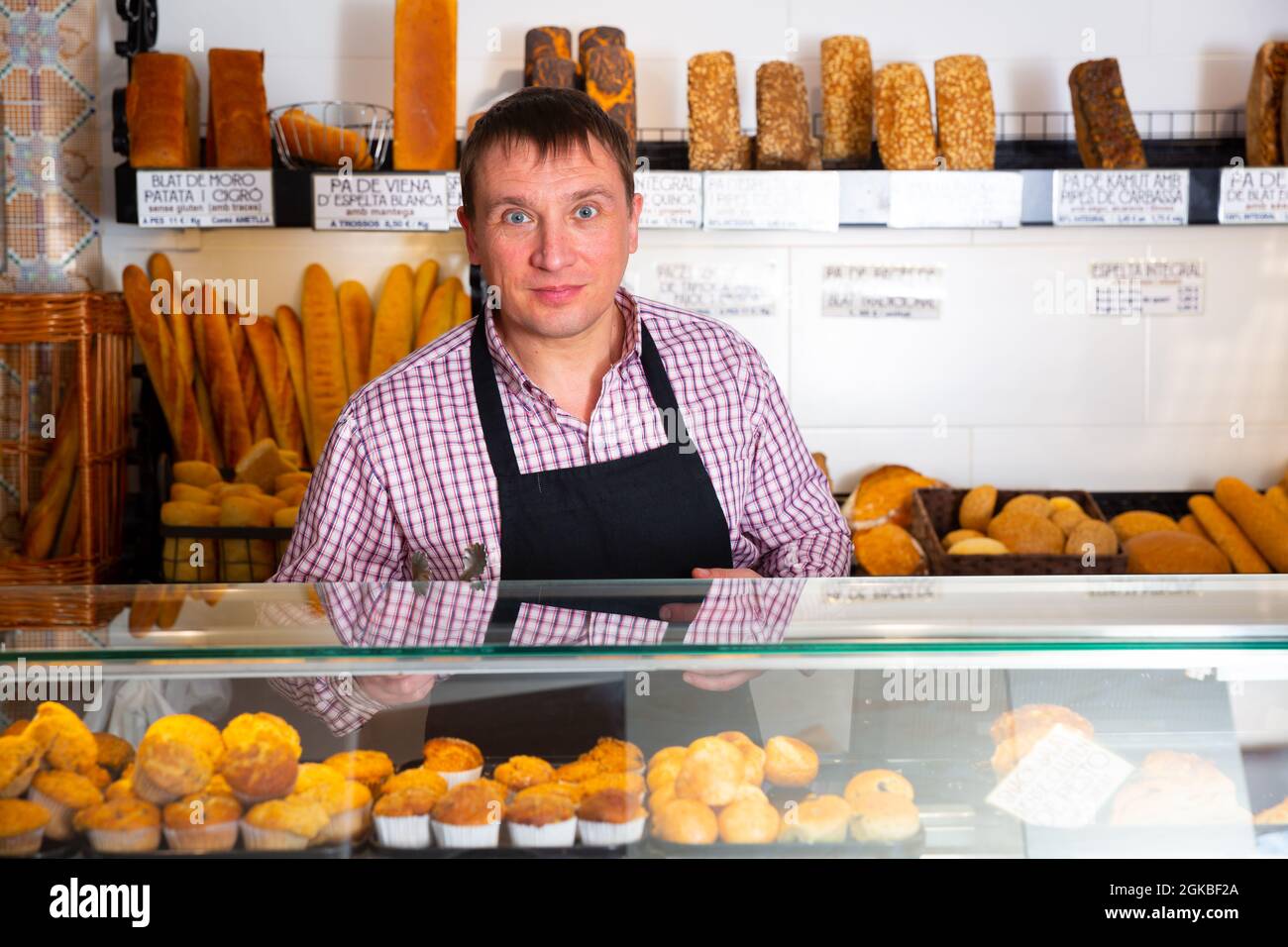 Baker working behind counter in bakery Stock Photo - Alamy