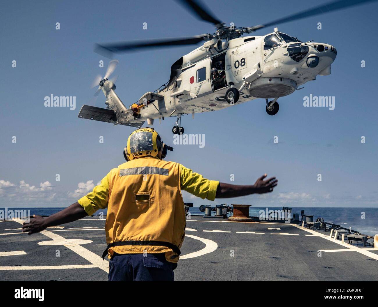 Boatswain’s Mate Seaman J-Ree Reeves signals to a Japan Maritime Self-Defense Force (JMSDF) SH ...