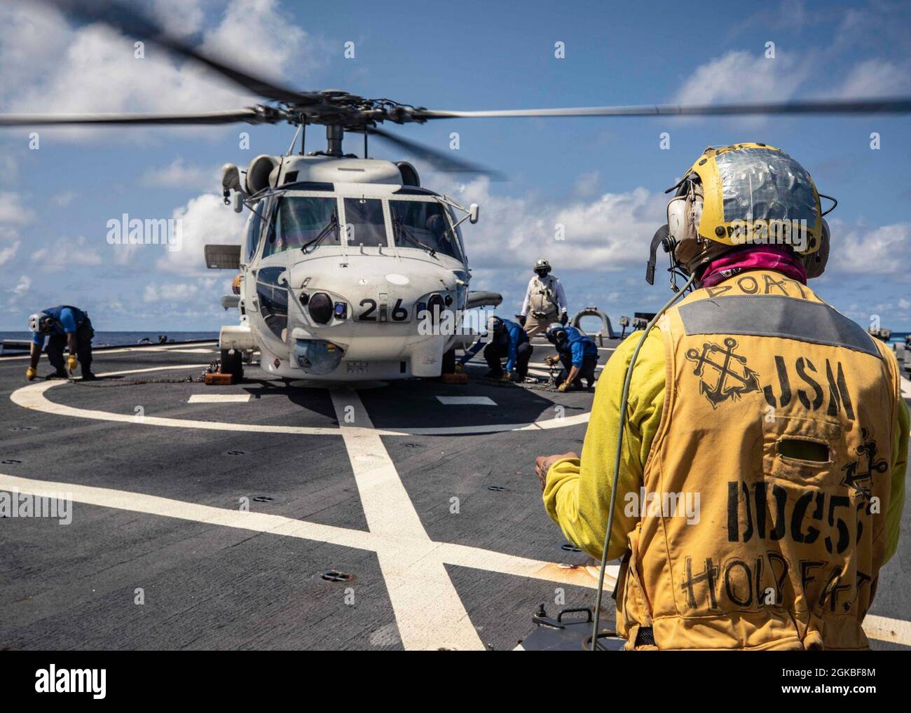 Sailors attach chocks and chains to a Japan Maritime Self-Defense Force ...