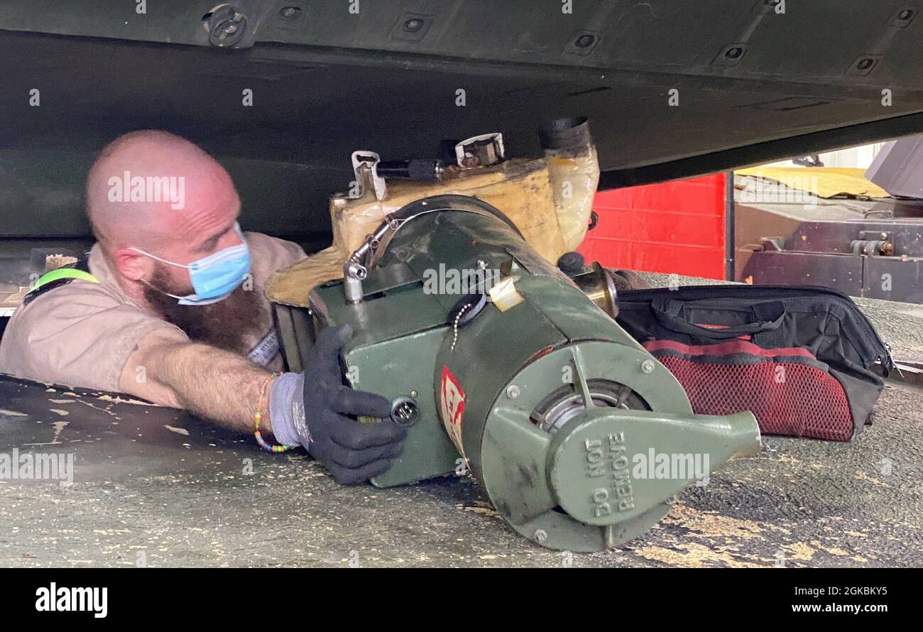 A mechanic at Coleman worksite drags a personnel heater into an M1 ...