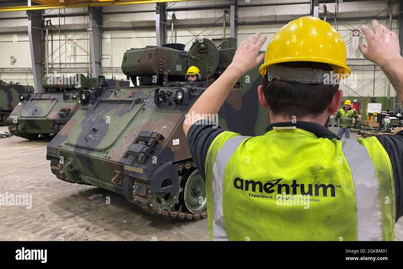 A contractor ground guides an armored personnel carrier inside one of ...