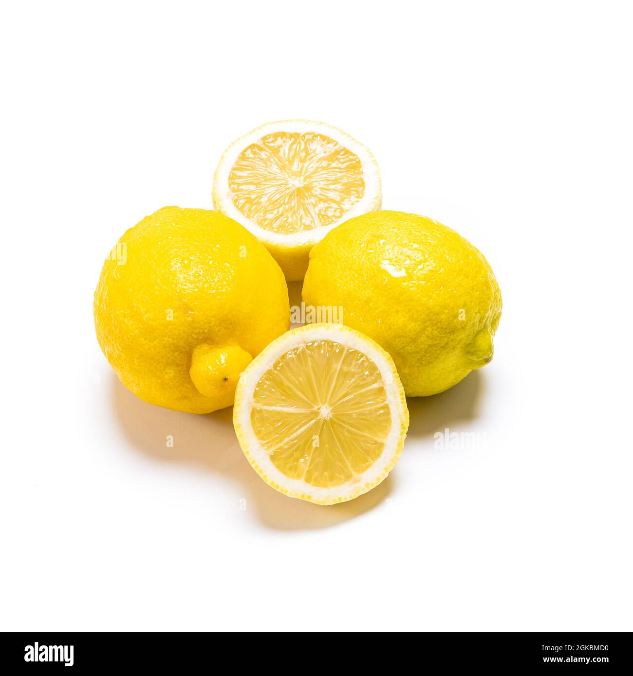 Photo of two lemons and a yellow lemon in two halves on a white ...