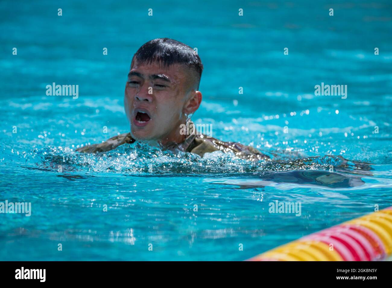 A competitor performs the 100-meter swimming challenge in the Hawaii ...
