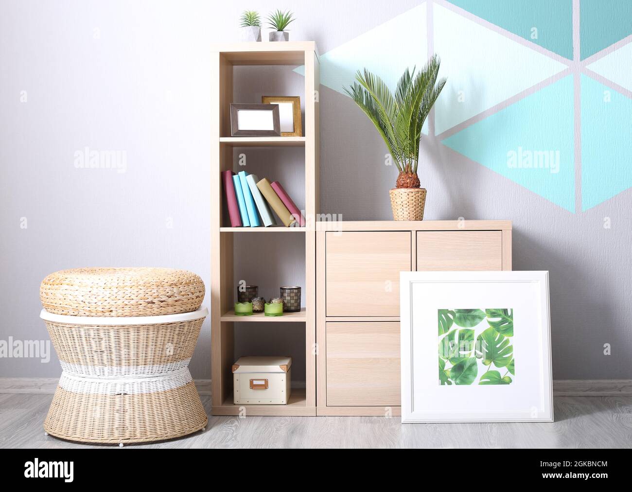 Modern room design with framed picture of tropical leaves, bookcase and ...