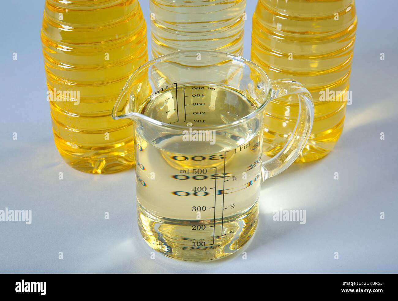 Beaker and bottles with cooking oil on light background Stock Photo - Alamy