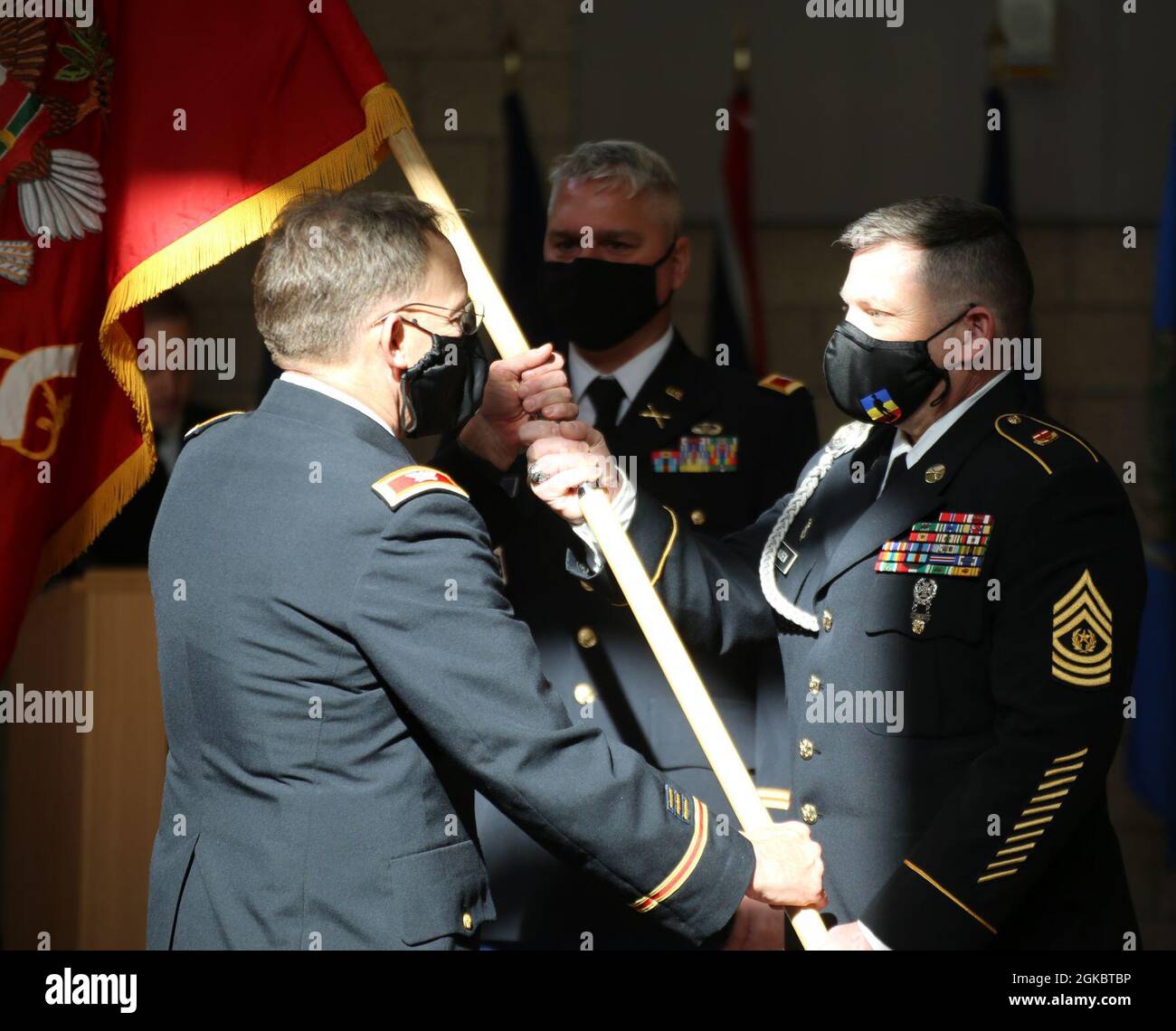 Command Sgt. Maj. Jason Ausen passes the colors to Col. Roger Wold ...