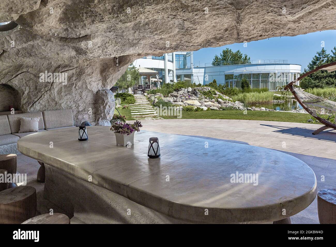 Marble table in rocky cave set up under patio in country estate with ...
