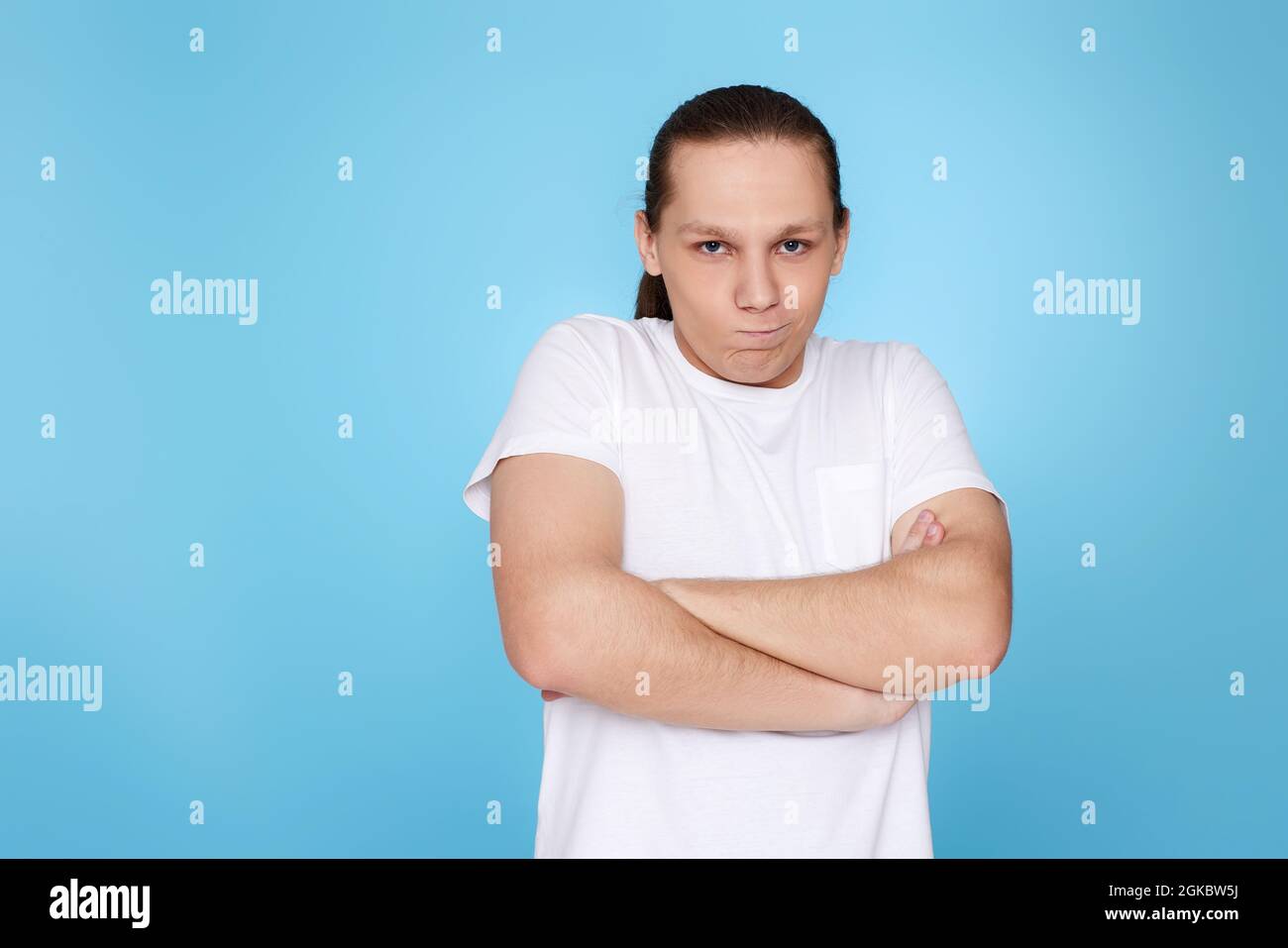 young man frowning isolated on blue background. Human emotions, facial ...