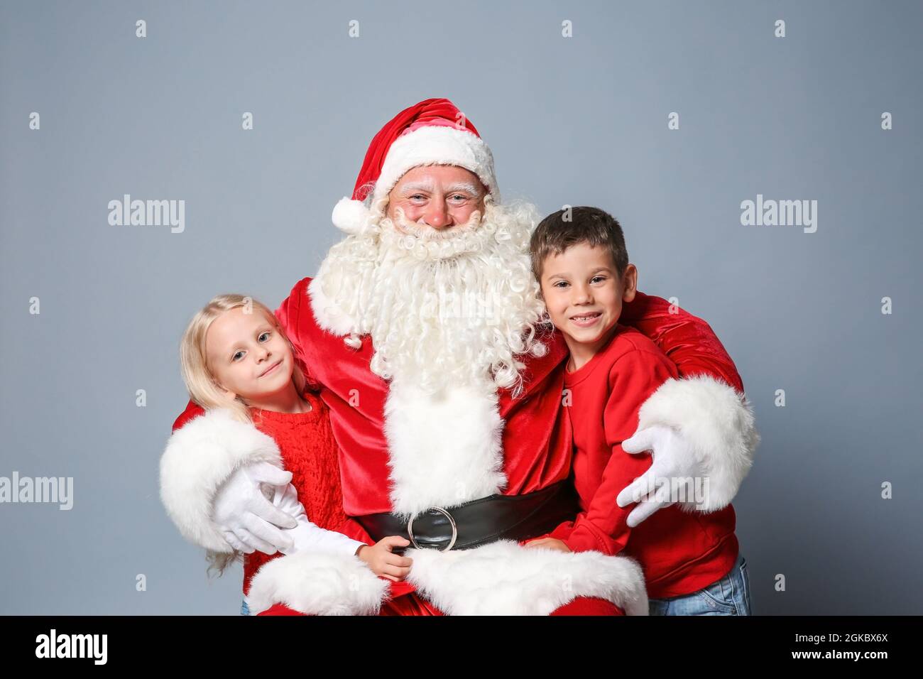 Santa Claus with cute children on color background Stock Photo - Alamy