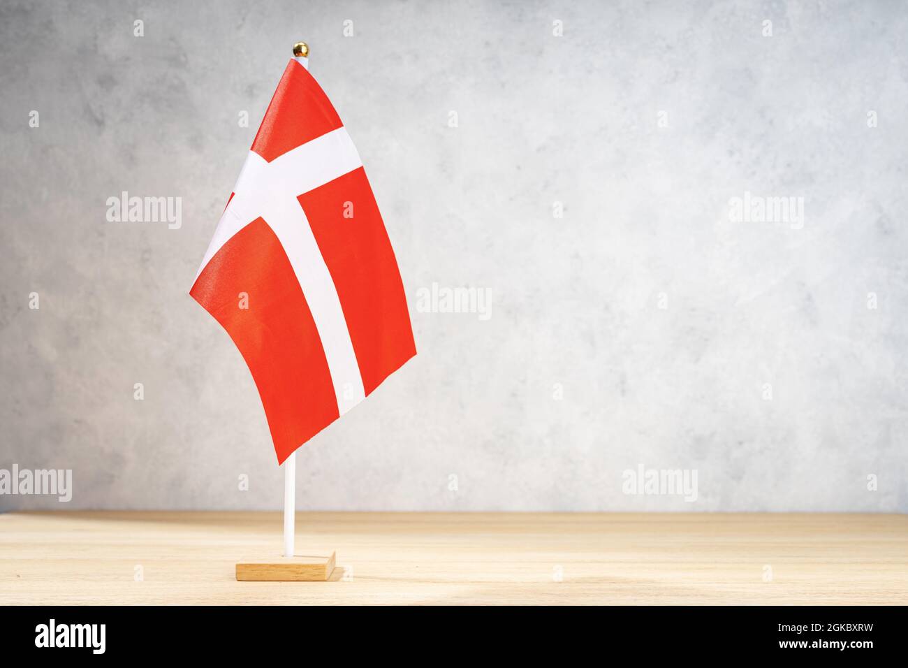 Denmark table flag on white textured wall. Copy space for text, designs ...