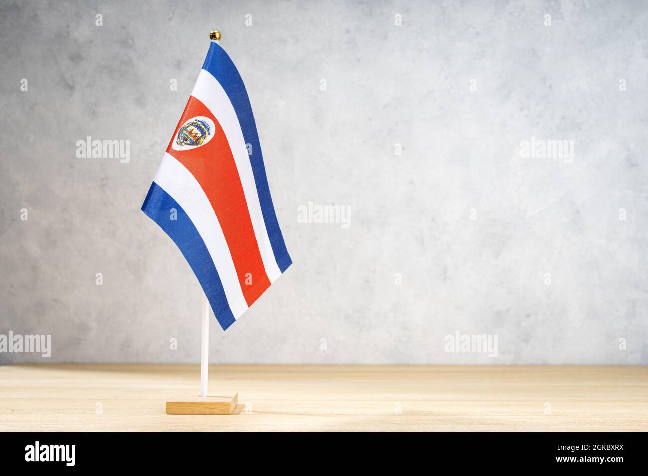 Costa Rica table flag on white textured wall. Copy space for text ...