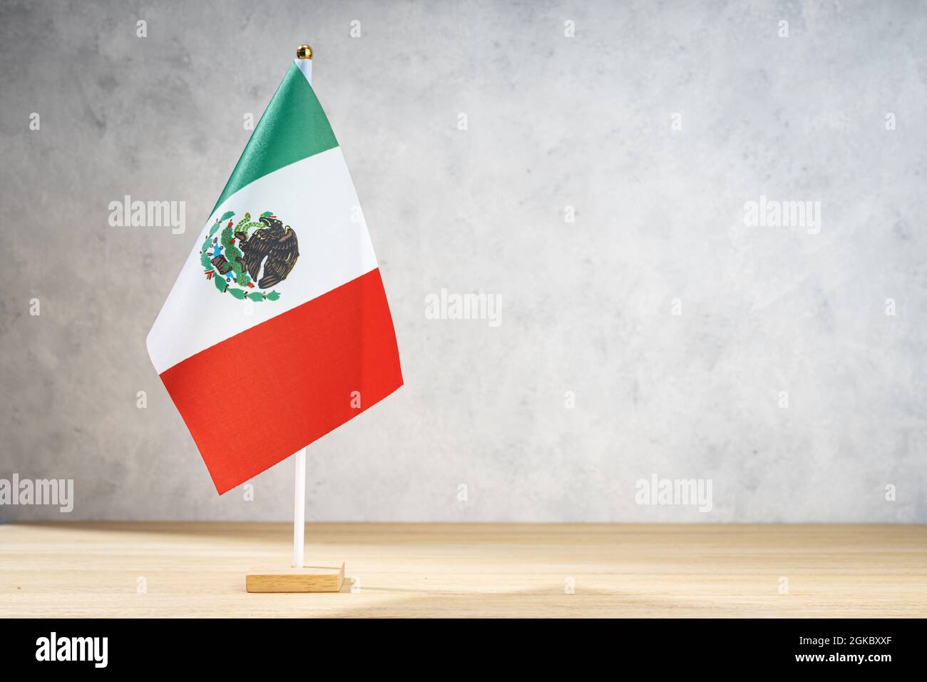 Mexico table flag on white textured wall. Copy space for text, designs ...