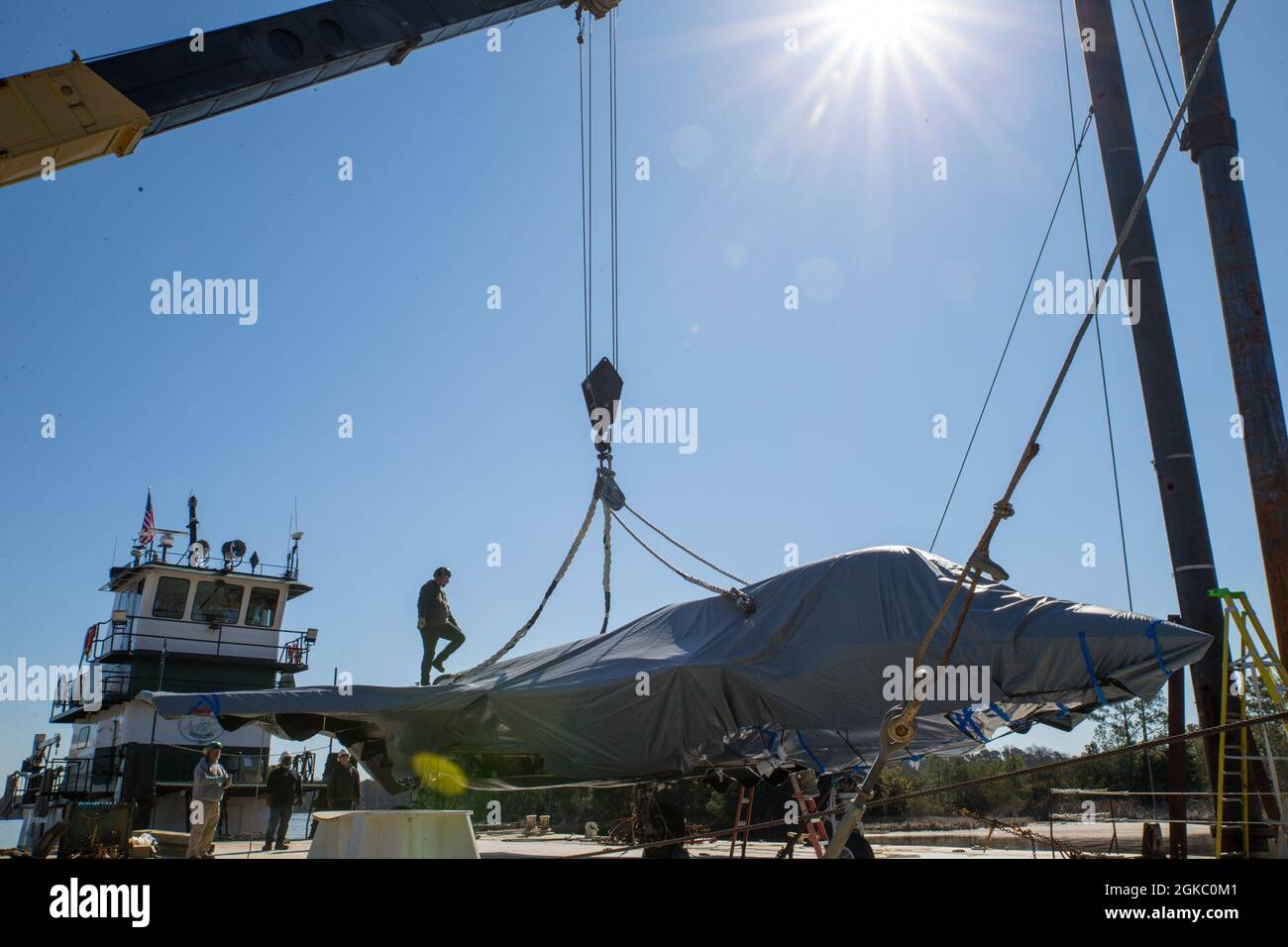 An F-35 airframe is hoisted off a barge after transit to Marine Corps ...