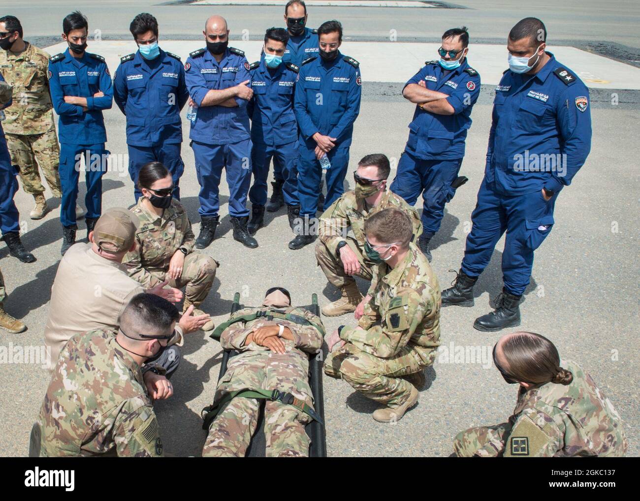 Members of the Kuwait Fire Force look on as Staff Sgt. Chase Isenberger ...