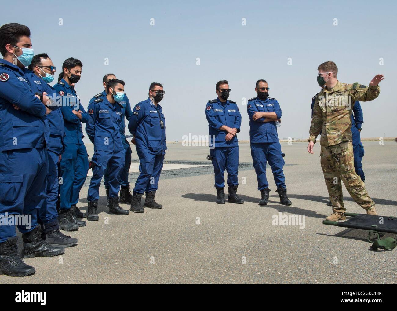 Members of the Kuwait Fire Force look on as Staff Sgt. Chase Isenberger ...