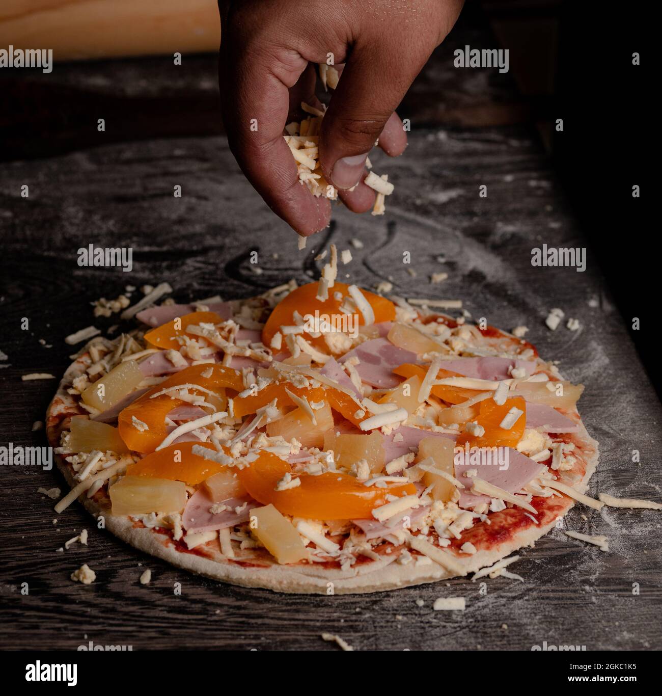 Closeup shot of a chef adding toppings to a gourmet pizza Stock Photo ...