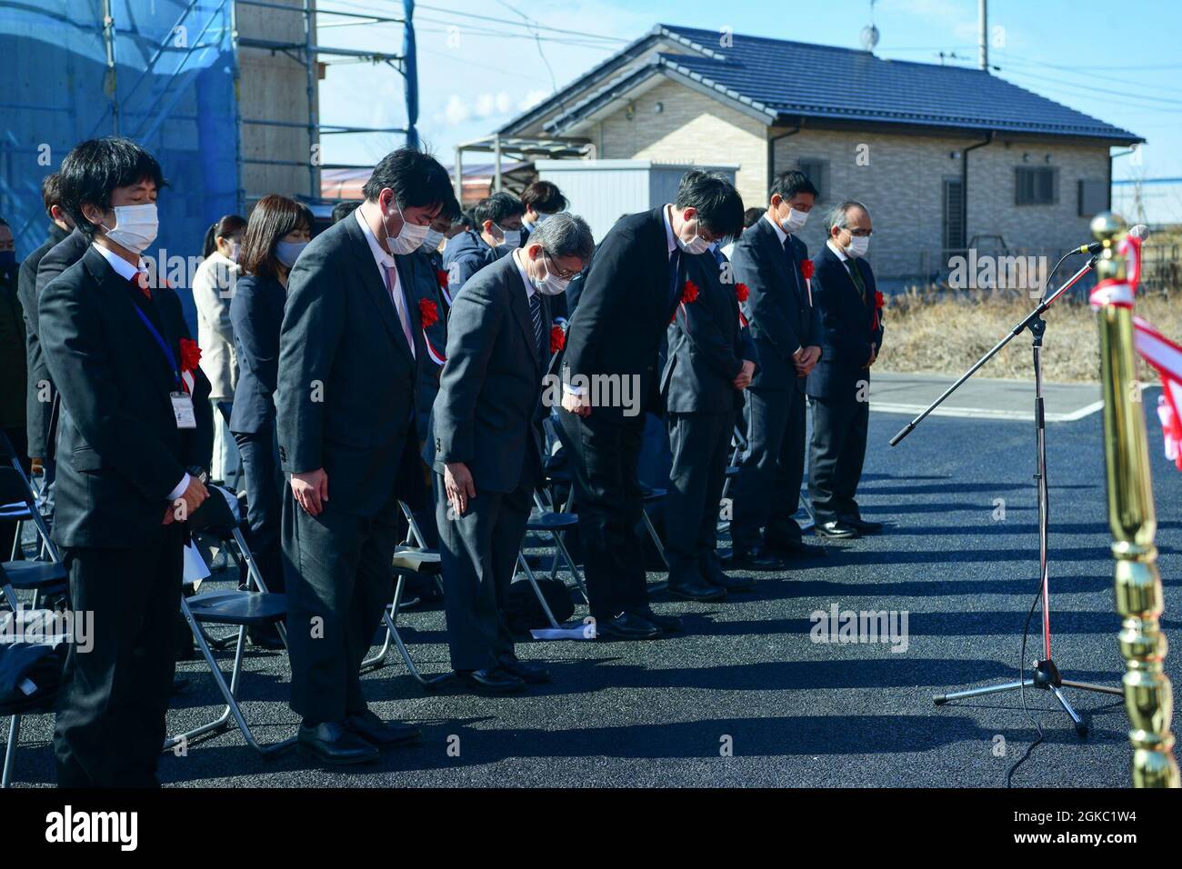 Japanese assemblymen from Miyagi Prefecture bow during a moment of ...
