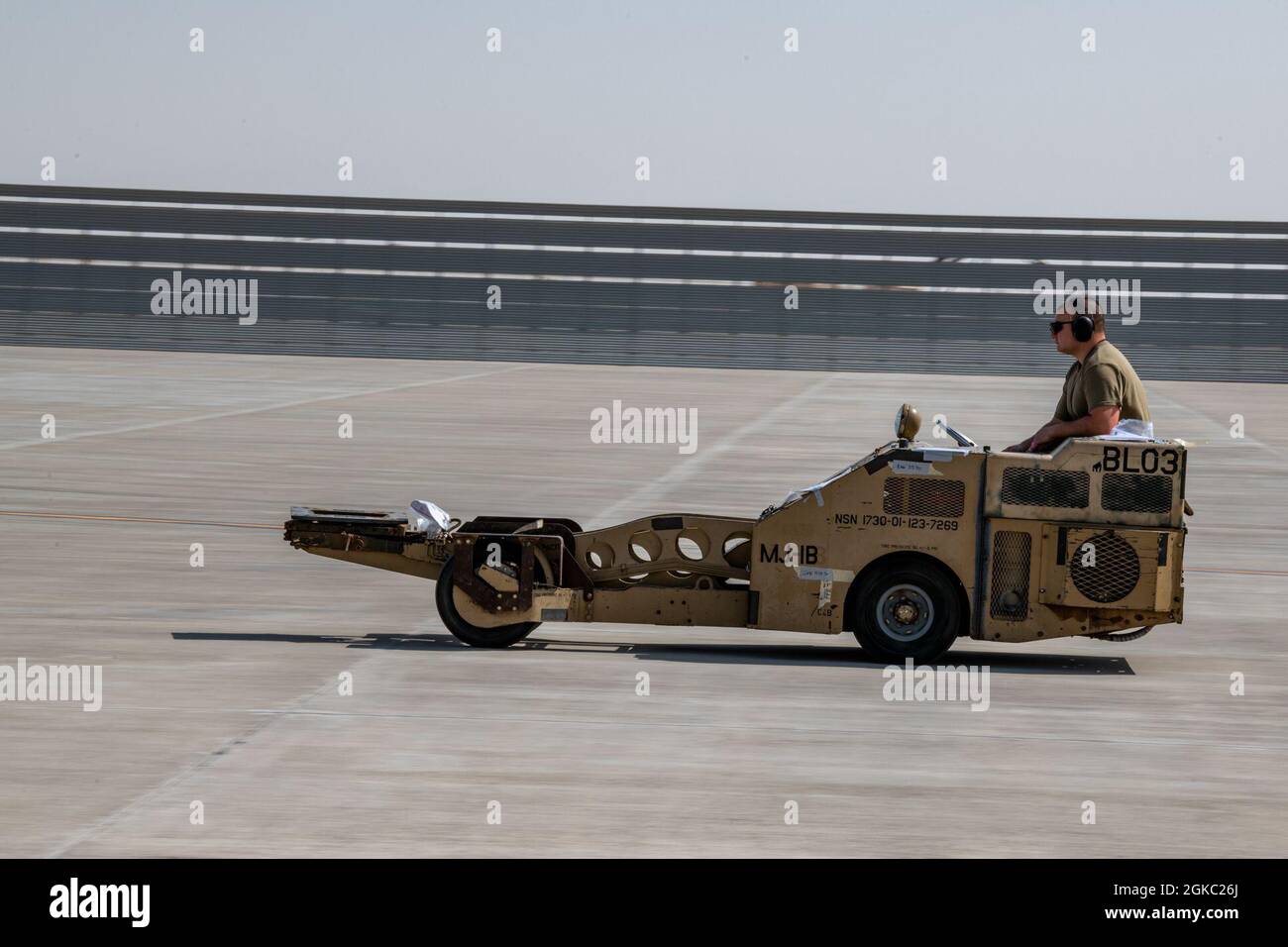 An Airman drives an MJ-1B bomb loader across the flightline at Al Udeid ...