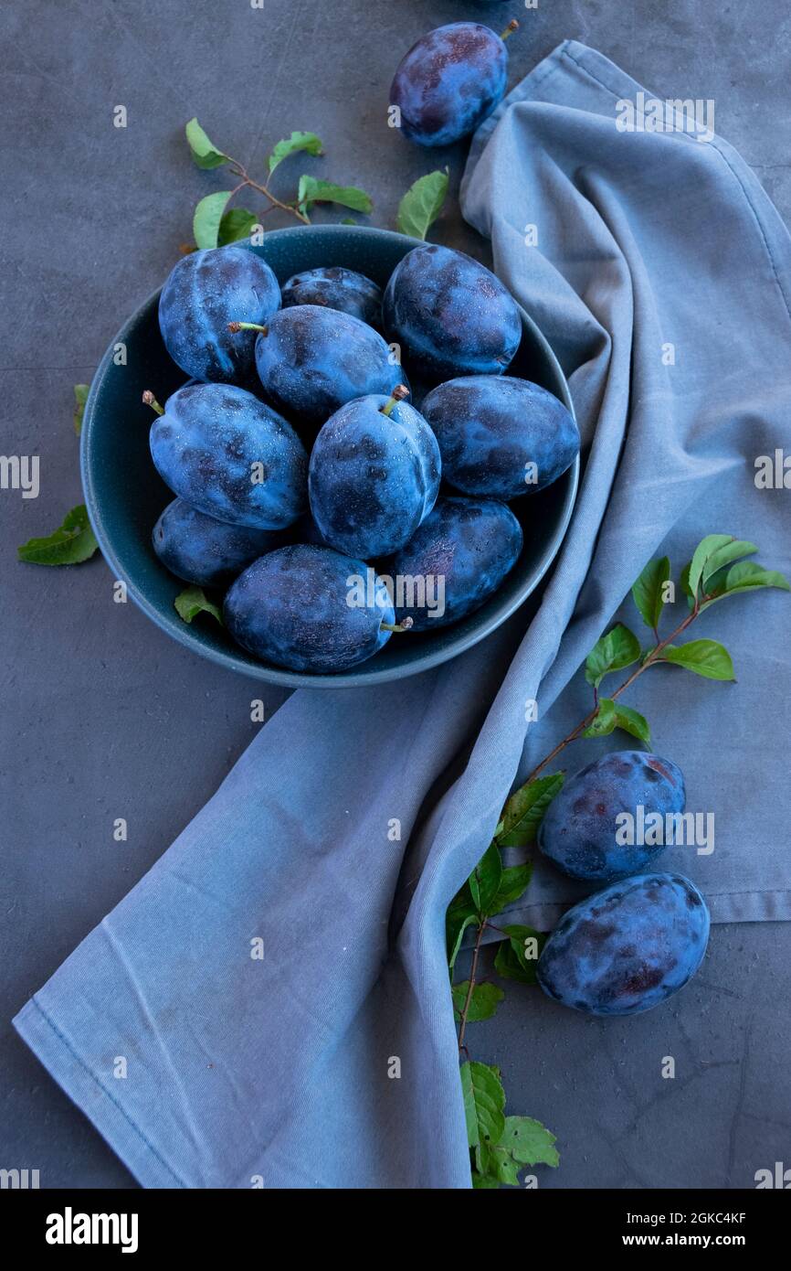 Fresh raw blue plums on the table, monochromatic color image Stock ...
