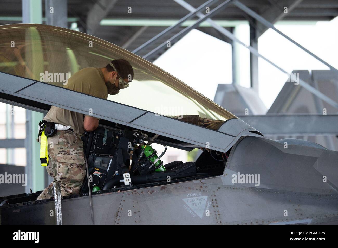 A maintainer from the 154th Aircraft Maintenance Squadron services an F ...