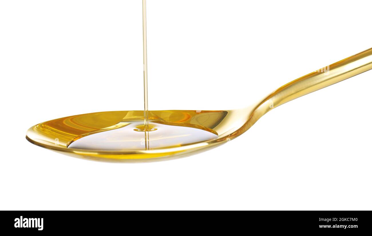Pouring cooking oil into spoon on white background Stock Photo - Alamy