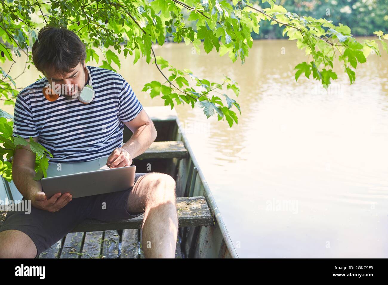 Programmer as a freelancer works on the laptop computer at the lake in ...