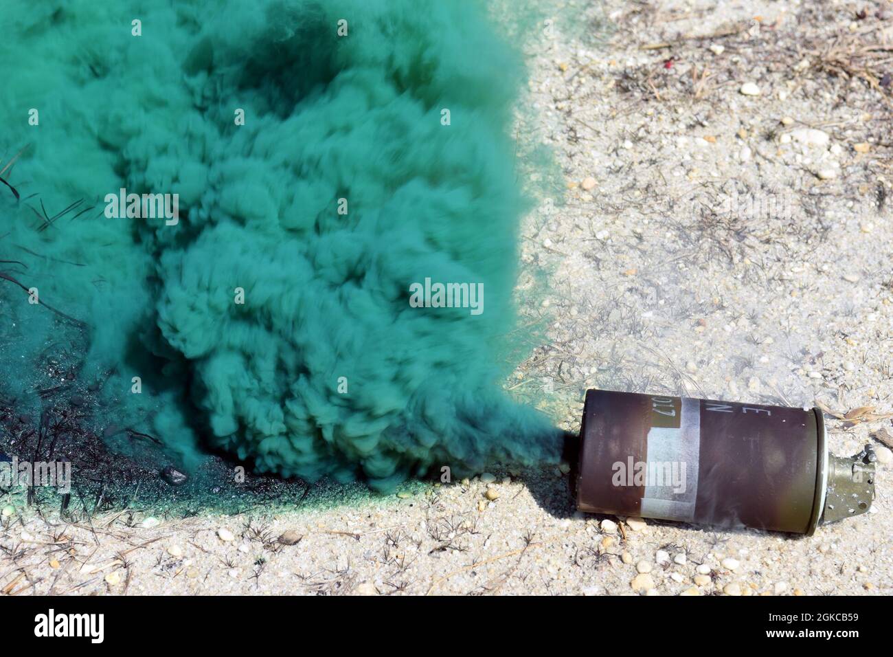 A green smoke grenade releases smoke during pyro training for the 174th ...