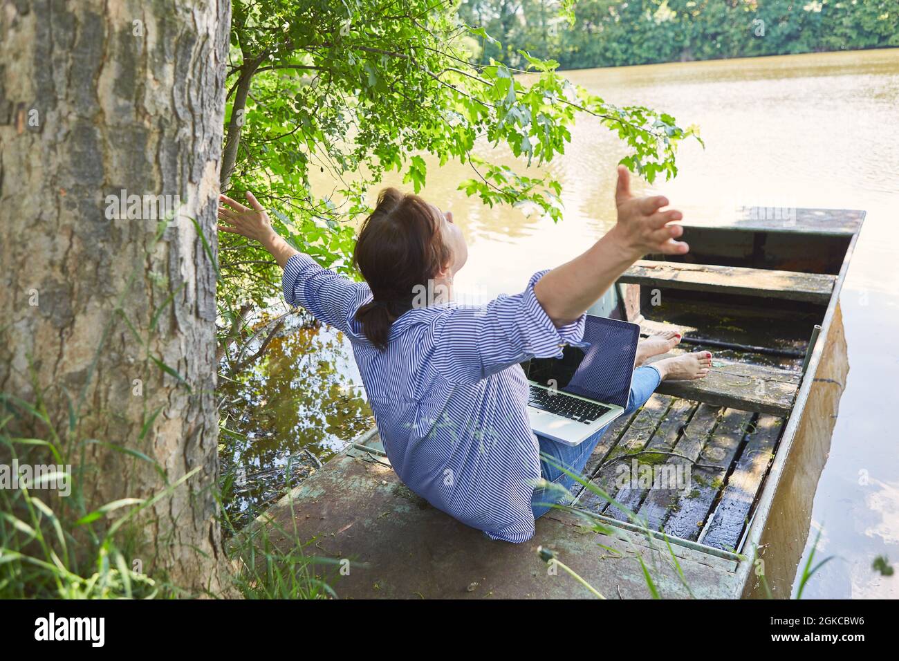 Business woman as a freelancer using laptop pc in an old boat on the ...