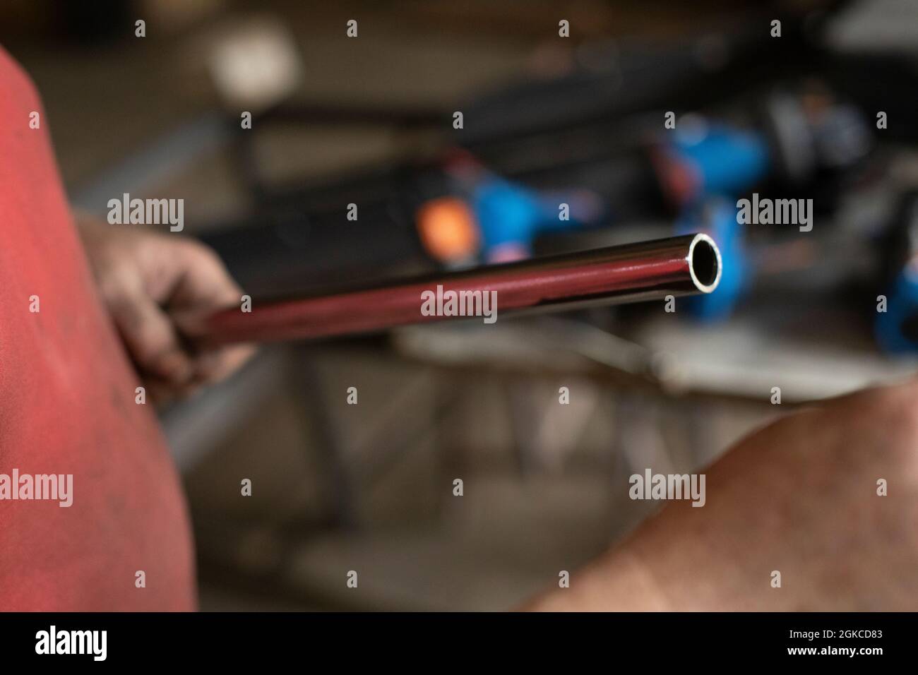 Steel pipe in hand. Small diameter of steel profile. A man holds a ...