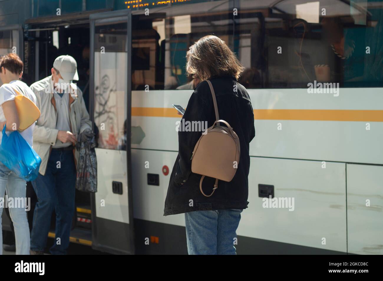 People at the bus stop. Waiting for transport. People stand by the road ...